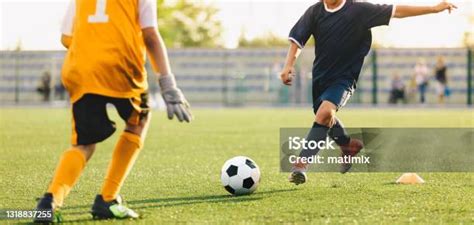 축구를 하는 아이들 젊은 골키퍼를 향해 공을 걷어차는 축구 포워드 플레이어 학교 잔디 경기장에서 축구 결투 아이에 대한 스톡 사진 및 기타 이미지 Istock
