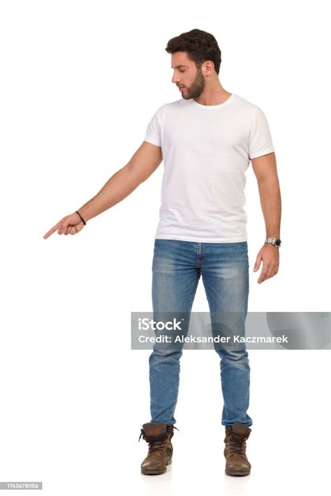 청바지와 흰색 티셔츠에 있는 진지한 젊은 남자는 서 있고 아래로 향하게 됩니다 전면 보기 T 셔츠에 대한 스톡 사진 및 기타 이미지 T 셔츠 가리키기 남성 Istock