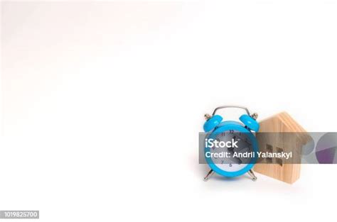 나무 집과 흰색 바탕에 파란색 알람 시계 임대 주택 월별와 시간별의 개념입니다 임시 숙박 시설 호텔 및 호스텔입니다 집을 구입 하는 대출 금융에 대한 스톡 사진 및 기타