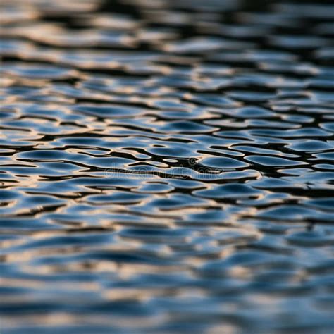 Rippling Water Surface Reflecting Soft Golden Light Creating A Pattern Of Gentle Waves Stock