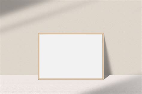 현실적인 풍경 사진 프레임 모형입니다 밝은 창 그림자 오버레이 효과가 있는 테이블 위의 나무 프레임 모형 단순하고 깨끗하며