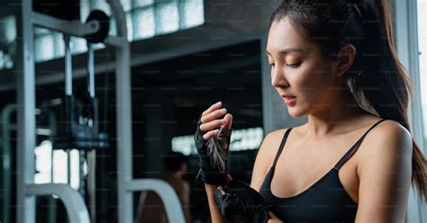 피트니스 체육관에서 운동 전에 스포츠 장갑을 끼고 운동복을 입은 건강한 아시아 운동 여성 웰빙 강한 여성은 스포츠 클럽에서 스포츠 훈련을 합니다 건강 관리 동기 부여