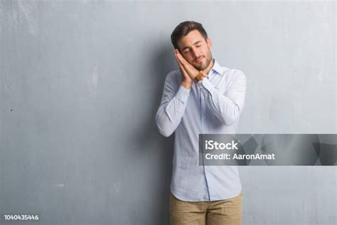 자 고 피곤 꿈 닫힌된 눈으로 웃 고 하는 동안 함께 손 포즈 우아한 셔츠를 입고 회색 그런 지 벽에 잘생긴 젊은 비즈니스 사람 긍정적인 감정 표현에 대한 스톡 사진 및