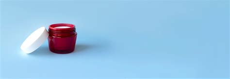 파란색 배경에 크림의 빨간 항아리 모의 얼굴 크림 배너 복사 공간 개념에 대한 스톡 사진 및 기타 이미지 개념 다중 색상