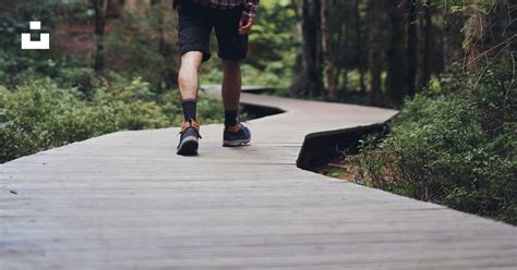 노란색과 검은색 체크무늬 셔츠를 입고 검은색 반바지를 입은 남자가 회색 콘크리트 통로에 둘러싸여 있다 사진 Unsplash의 무료 자연 이미지