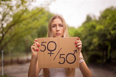 Gender Equality Concept As Woman Hands Holding A Paper Sheet With Male And Female Symbol Over A