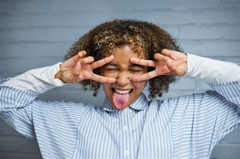 Joyful Individual Making Fun Gesture By Holding Peace Signs And