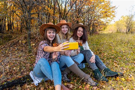 세 명의 다양한 여자 친구가 전화로 셀카를 찍습니다 공원에서 야외에서 가을 풍경 10월에 대한 스톡 사진 및 기타 이미지