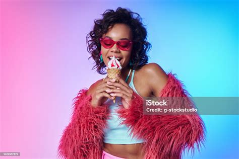화려한 배경에 아이스크림을 먹는 푹신한 재킷을 입은 아름다운 아프리카 여성 개성 개념에 대한 스톡 사진 및 기타 이미지 개성 개념 그라데이션 냉동식품 Istock