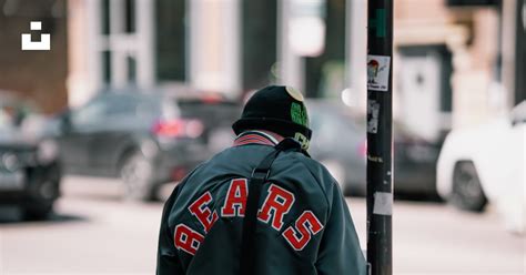 낮 동안 보도에 서 있는 검은색과 빨간색 까마귀를 입은 남자 사진 Unsplash의 무료 자동차 이미지