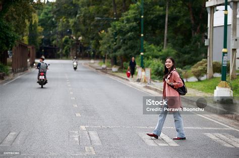 도시 거리의 횡단보도를 건너 배낭을 메고 웃고 있는 학생 흐릿한 교통 체증을 배경으로 20 29세에 대한 스톡 사진 및 기타
