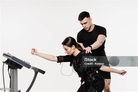 트레이너는 Ems 전기 근육 자극 슈트를 사용한 운동의 예를 보여줍니다 근육을 활성화하기 위해 전기 자극을 가하는 Ems 슈트를 입은 그룹 운동 훈련 18 19세에 대한