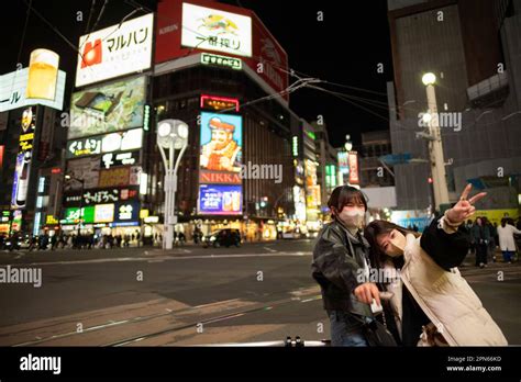 Women Pose For A Photo At A Famed Traffic Intersection In The Susukino District Of Sapporo