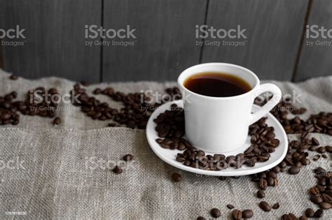 린넨 배경에 구운 커피 콩을 곁들인 커피 컵 흩어져 있는 커피 콩을 곁들인 검은 색 코프 잔 신선한 커피 콩 갈색에 대한 스톡 사진 및 기타 이미지 Istock