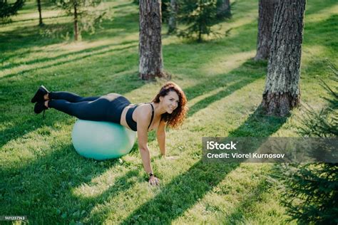 젊은 기쁘게 스포티 한 여자는 피트니스 공과 피트니스 운동을 녹색 공원이나 숲에서 요가연습 에어로빅 강사인 건강하고 적합 유지