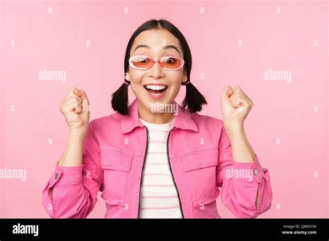 Portrait Of Excited Japanese Girl In Sunglasses Celebrating Achieve