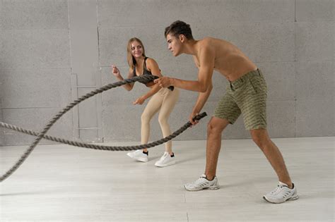 개인 트레이너는 체육관에서 전투 밧줄에 클라이언트와 종사한다 그녀의 클라이언트와 함께 몇 가지 교차 훈련 운동을하는 운동 여성 2명에 대한 스톡 사진 및 기타 이미지