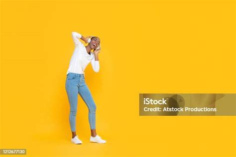 복사 공간 노란색 스튜디오 배경에 고립 된 헤드폰에 음악을 듣고 행복 미소 젊은 아프리카 계 미국인 여성 전신에 대한 스톡 사진 및 기타 이미지 Istock