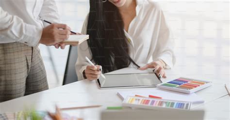 현대 직장에서 디지털 태블릿으로 프로젝트를 진행하는 젊은 디자이너의 자른 샷 사진 Unsplash의 기업 사업 이미지