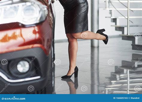 Legs Only Pretty Woman In Black Skirt Posing Near Brand New Car In Automobile Salon Stock Image