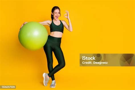 밝은 노란색 배경에 고립 된 Oksign 윙크를 보여주는 손 피트니스 볼에 들고 좋은 쾌활한 소녀의 전체 길이 바디 사이즈 보기 매우 기쁜에 대한 스톡 사진 및 기타 이미지