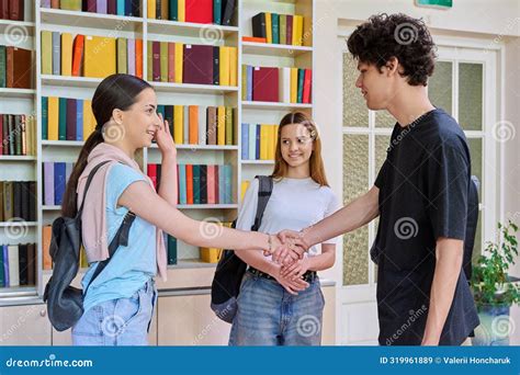 Meeting Of Classmates In High School Library Teenagers Shaking Hands