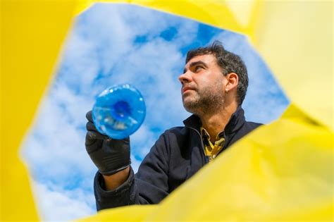 Premium Photo Man Throwing A Bottle Into A Garbage Bag On The Beach Ecology Sea Pollution