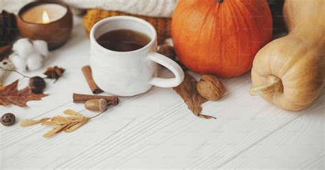 가을 잎 호박 아늑한 스웨터 세련된 방에서 흰 나무에 촛불을 태우는 배경에 따뜻한 차 한잔 안녕하세요 가을 아늑한 느린 생활 행복한 추수 감사절 사진