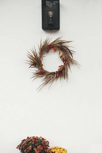 세련된 가을 화환은 야외 흰색 벽에 현대 등불에 매달려 있습니다 가을 장식 및 농가 외관의 배치 말린 풀 열매 허브 및 잎이있는 소박한 가을 화환 0명에 대한 스톡 사진 및
