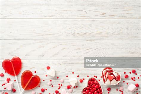 발렌타인 데이 개념입니다 빈 공간이 있는 흰색 나무 책상 배경에 과자 젤리 사탕과 막대 사탕이 있는 하트 모양의 접시의 상위 뷰 사진 0명에 대한 스톡 사진 및 기타 이미지