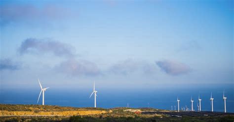 배경에 태양 전지판과 풍차의 큰 농장 테네리페에서 전기 에너지의 친환경적이고 깨끗한 생산 산과 아름다운 풍경을 배경으로 사진 Unsplash의 풍력 터빈 이미지