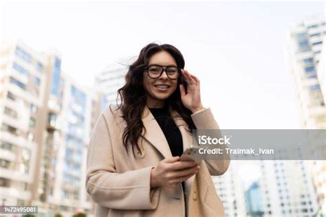 도시의 배경에 그녀의 손에 휴대 전화를 가진 안경에 성공적인 젊은 여자 25 29세에 대한 스톡 사진 및 기타 이미지 25 29세 건물 외관 경영자 Istock