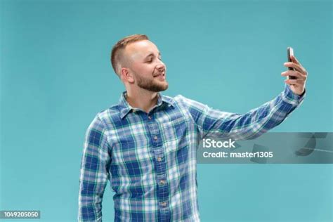 그의 스마트폰으로 Selfie를 복용 하는 매력적인 젊은 남자의 초상화 파란색 배경에 고립 남자에 대한 스톡 사진 및 기타 이미지 Istock