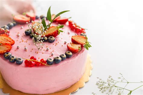 딸기 블루 베리 붉은 건포도와 꽃 딸기로 장식 된 수제 핑크 생일 케이크 음식 개념입니다 흰색 배경에 소녀 생일 또는 웨딩 크림 치즈 핑크 케이크입니다 복사 공간 후식
