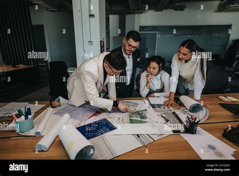 Team Collaborates On Project Planning With Architectural Blueprints