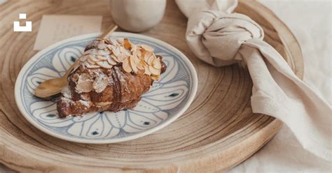 갈색 나무 테이블에 흰색 세라믹 머그잔 옆에 흰색 세라믹 접시에 갈색 빵 사진 Unsplash의 무료 음식 이미지