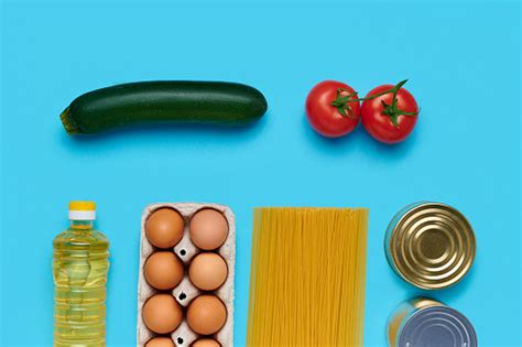 상단 보기 플랫레이 파란색 배경에 있는 제품 집합입니다 가게에서 음식 해바라기 기름 계란 통조림 식품 파스타 신선한 토마토 호박 쿠르제트 배달 및 기부 개념 0명에 대한