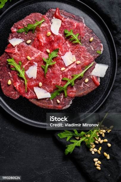 파마산 소스 치즈 아루굴라를 곁들인 블랙 플레이트에 소고기 카르파치오 검은 색 배경입니다 맨 위 보기 건강한 식생활에 대한 스톡 사진 및 기타 이미지 Istock