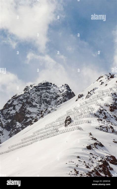 Snowy Rocky Mountains With Avalanche Protection Barriers Vertical Copy
