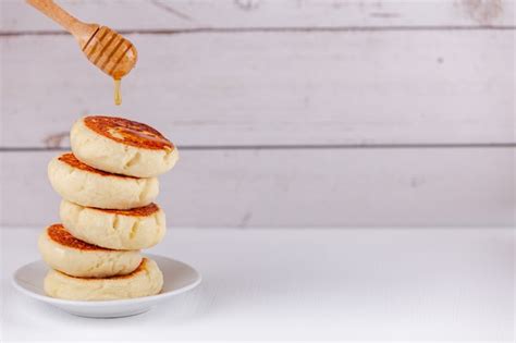 러시아 디저트 코티지 치즈 팬케이크 Syrniki 물이 뚝뚝 떨어지는 꿀 디퍼 프리미엄 사진