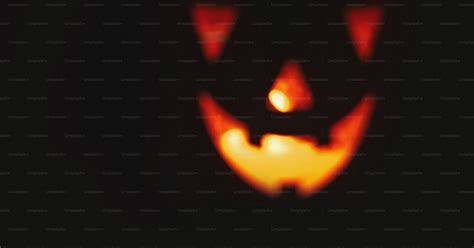 검은 배경에 무서운 빛나는 얼굴을 가진 할로윈 호박이 고립되어 있습니다 어둠 속에서 빛나는 호박 잭 오 랜턴 과자 안 주면 장난칠 거예요 텍스트를 위한 공간입니다