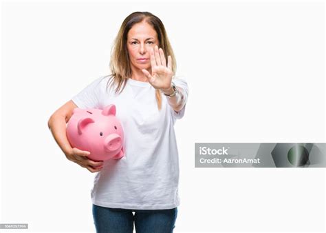 중세 스페인 여자 오픈 손으로 하 고 심각 하 고 자신감 표현 방어 제스처와 정지 신호 절연된 배경 위에 돼지 저금통을 사용 하 여 비용을 절약 갈색 머리에 대한 스톡 사진