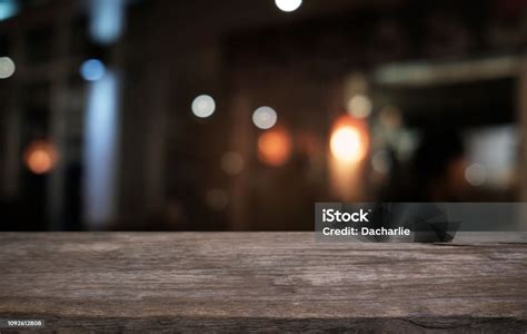 레스토랑의 추상 흐리게 Bokeh 배경 앞 빈 어두운 나무 테이블 디스플레이에 사용할 수 있습니다 또는 귀하의 제품을 몽타주 공간에 대 한 조롱 가정의 방에 대한 스톡 사진