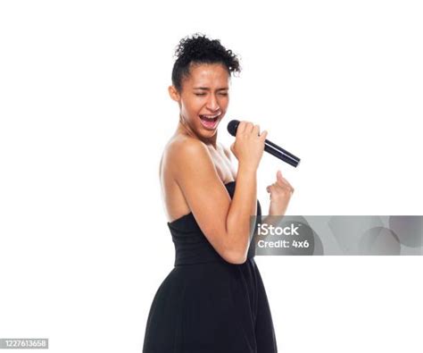 흰색 배경 앞에서 춤을 추는 아프리카 인종 여성 드레스와 들고 마이크 긍정적인 감정 표현에 대한 스톡 사진 및 기타 이미지 긍정적인 감정 표현 노래 드레스 Istock