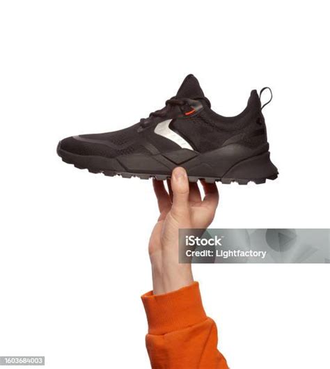 흰색 바탕에 고립된 트렌디한 검은색 운동화를 들고 있는 남자의 손 스포츠 신발을 사용한 창의적인 미니멀리즘 레이아웃 할인 프로모션 포스터 강사에 대한 스톡 사진 및 기타