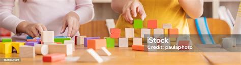 교실에서 블록 놀이를 하는 어린 아이들의 손을 감쌉니다 교육 그룹 학습 개념을 재생하여 학습합니다 국제 학생들은 초등학교 배경 배너에서 활동 두뇌 훈련을 한다 아이에 대한