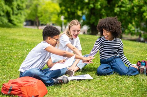 금발 소녀와 두 명의 아프리카계 미국인 아이들이 공원에서 함께 시간을 보내고 있다 10 11세에 대한 스톡 사진 및 기타 이미지 10 11세 25 29세 8 9 살