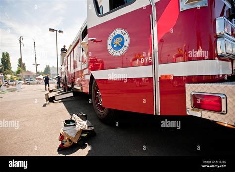 Two Fire Fighters Standing By A Fire Truck On Display Hi Res Stock