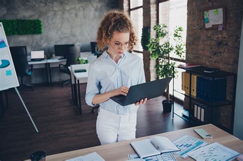 문서와 차트로 둘러싸인 현대적인 사무실에서 노트북으로 작업하는 젊은 여성 전문가 20 24세에 대한 스톡 사진 및 기타 이미지 20 24세 경영자 계획 Istock