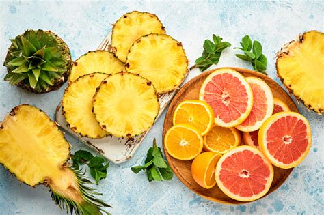 밝은 파란색 돌 배경에 슬라이스 잘 익은 파인애플 오렌지와 자몽 열대 과일 맨 위 보기입니다 텍스트에 대한 여유 공간입니다 모의 가느다란 관에 대한 스톡 사진 및 기타